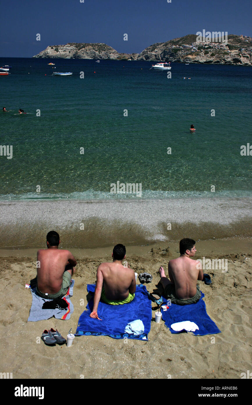 Boys on the Beach Three men lounge on a beach The blue water and gentle ...