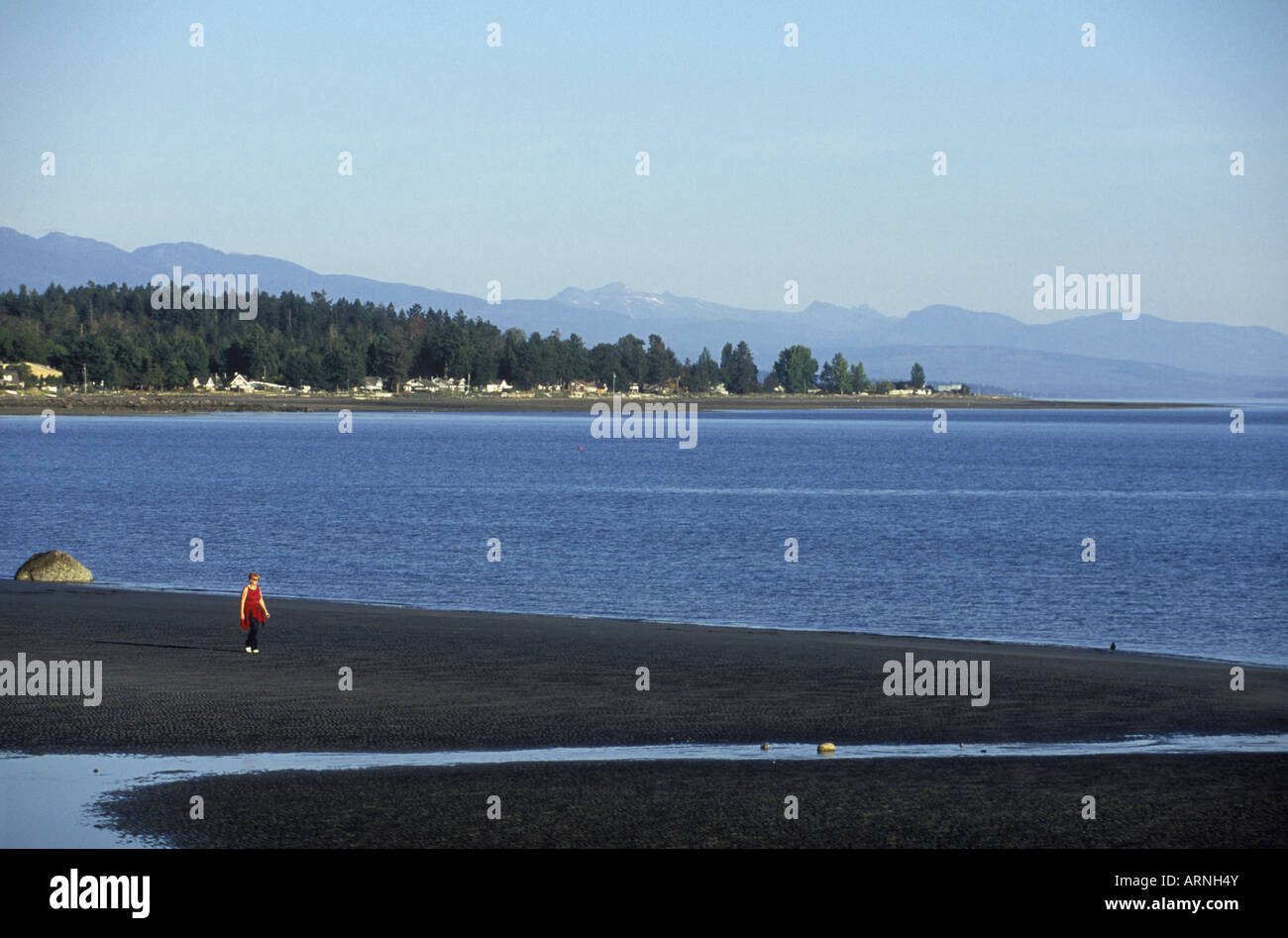 Qualicum Beach,woman walks along beach in morning, Vancouver Island ...