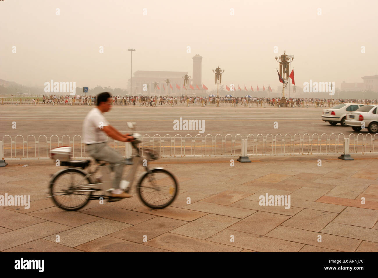 Moped rider and air pollution riding by Tiananmen Square in Beijing ...