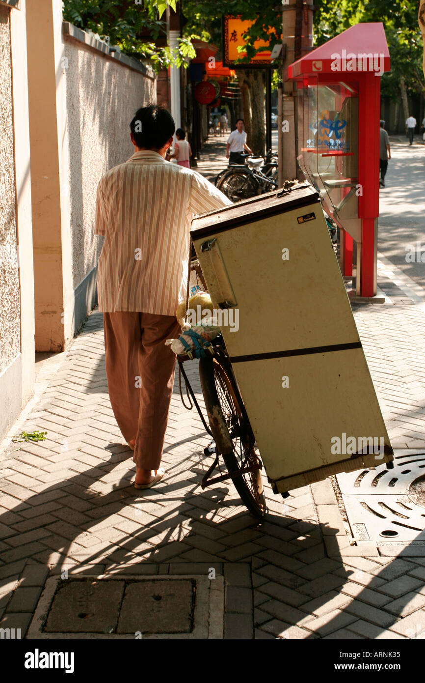 Man carrying a fridge on his bicycle in Shanghai China Stock Photo - Alamy