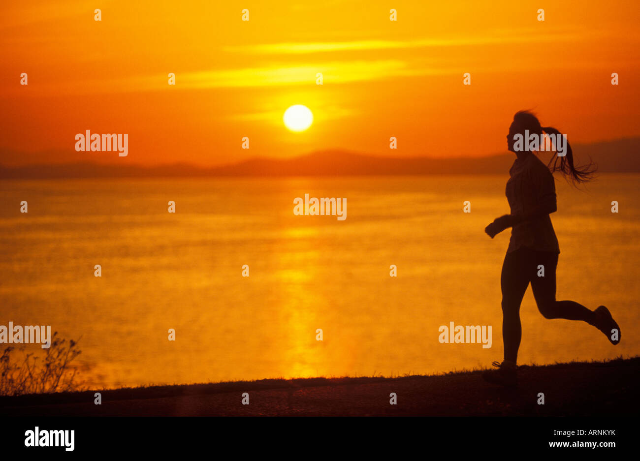 female runner at sunset, Dallas Road, Victoria, Vancouver Island ...