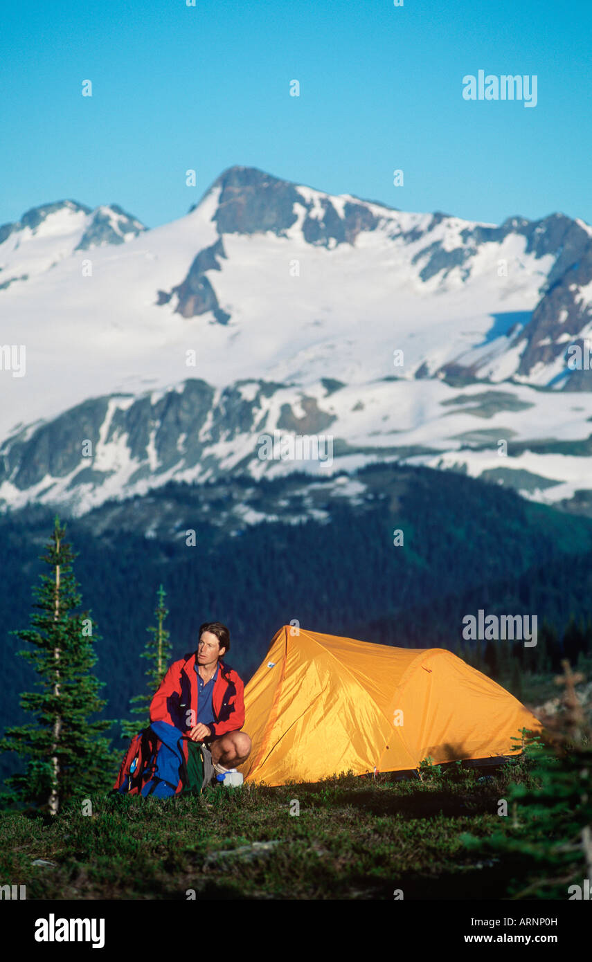 Man camps in meadow with mountain backdrop in Whistler Alpine, Whistler ...