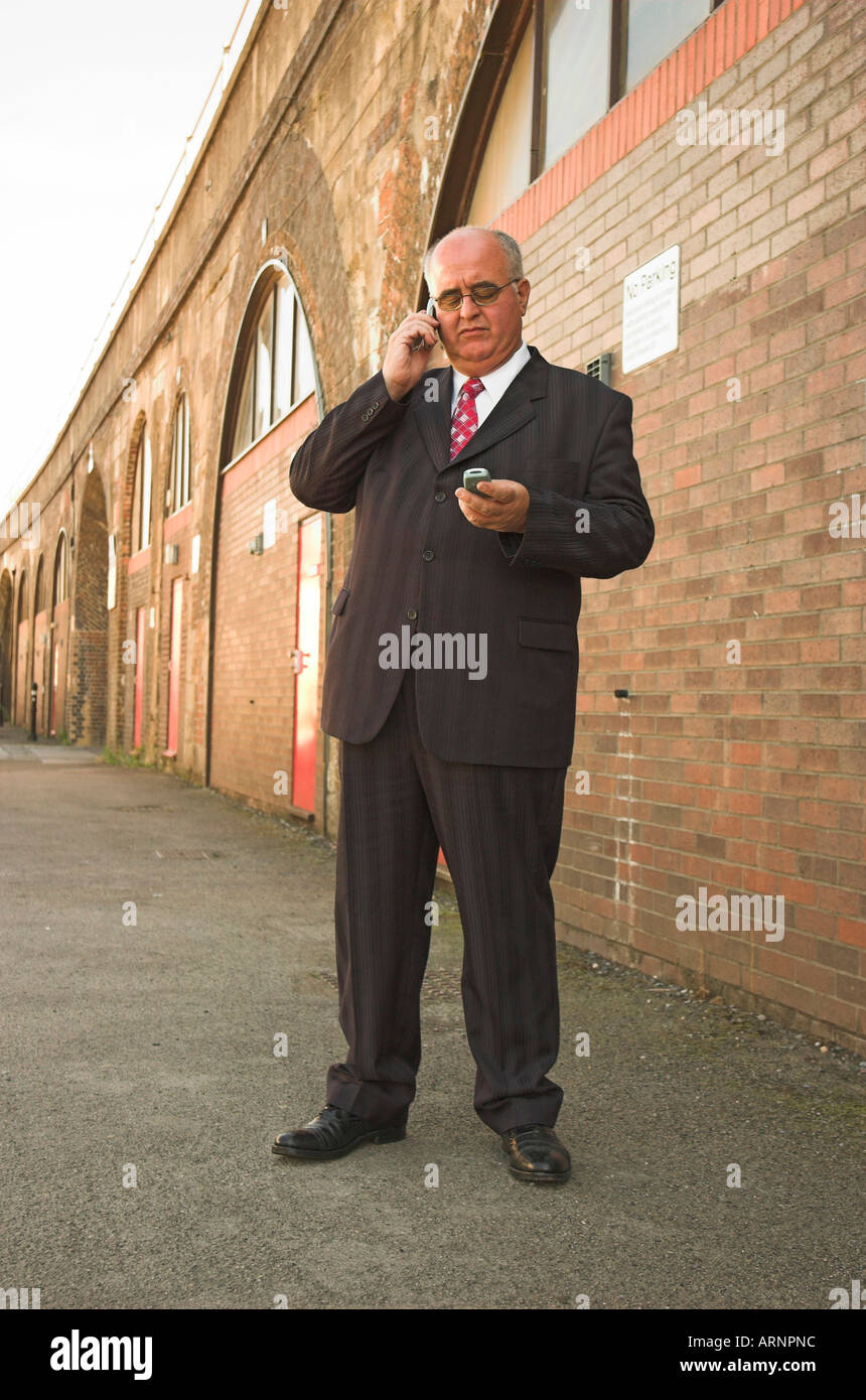 Business man multitasking using two mobile phones juggling cell phone ...