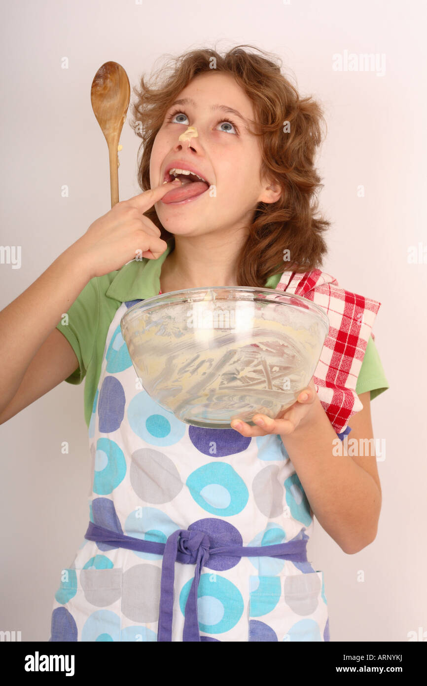 Teenage girl making baking cooking cakes with pinafore and bowel ...