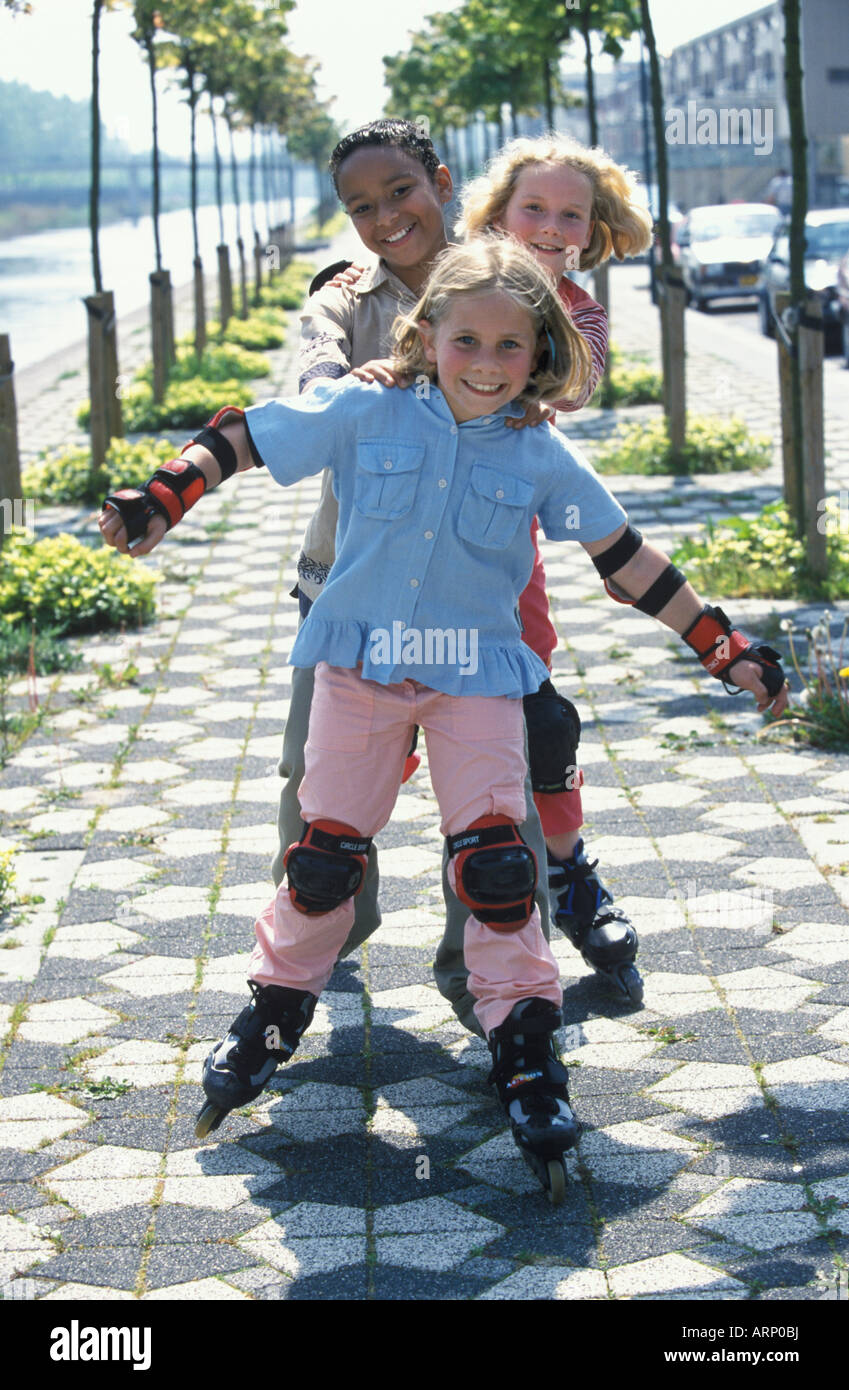 Three kids on roller skates Stock Photo - Alamy