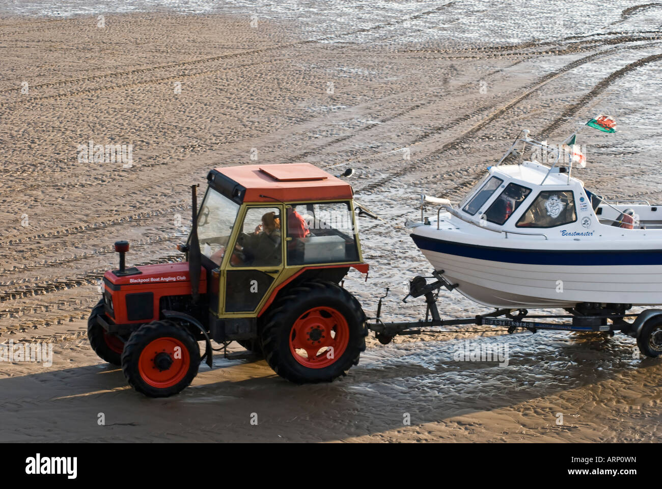 Tractor wet sand tracks sailing club Stock Photo - Alamy