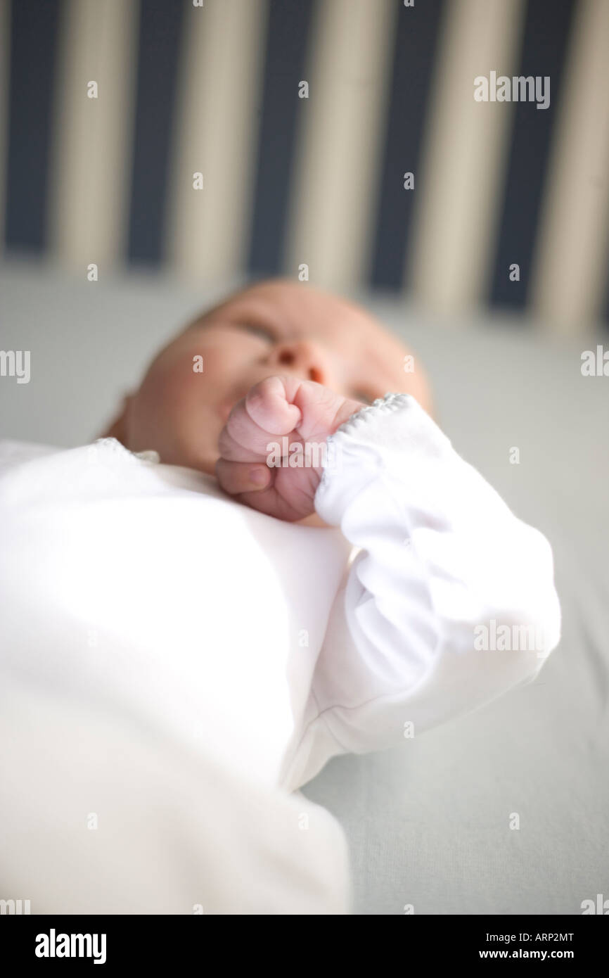 two month old baby mouthing wrist in crib, self soothing, awake Stock ...