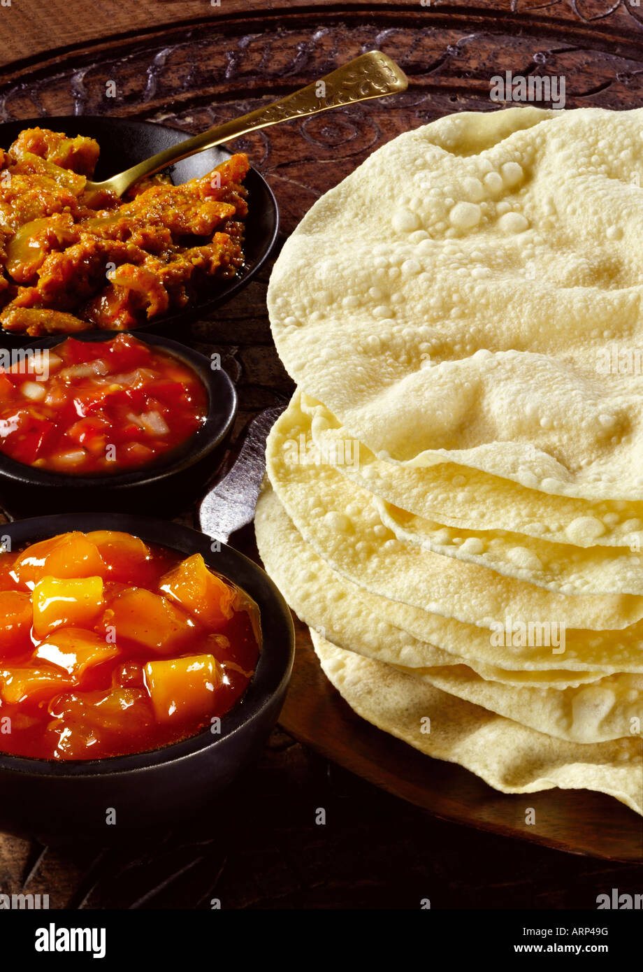 A pile of plain puppodums with Indian dips Stock Photo - Alamy