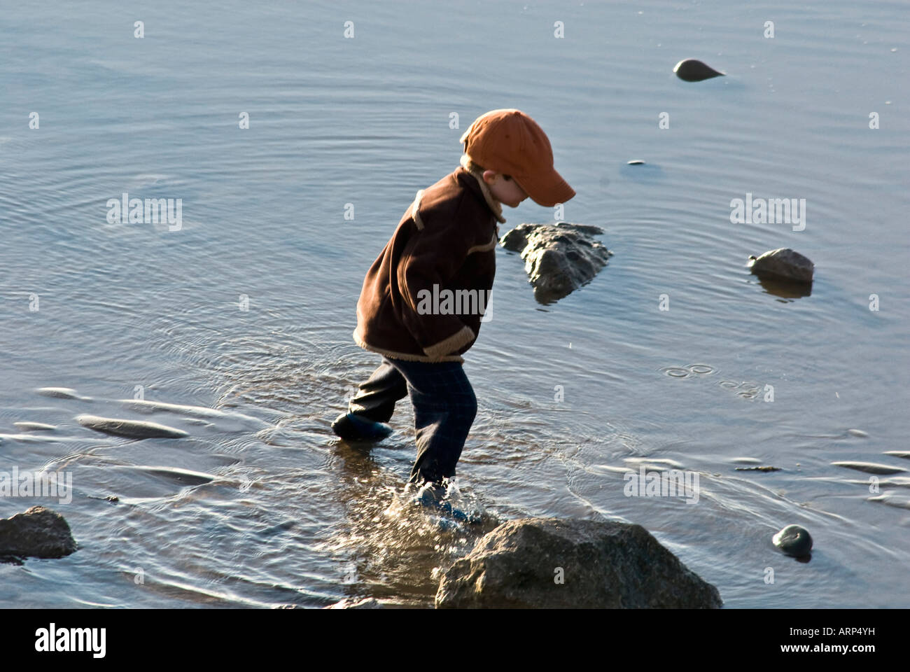 Boy child paddling sea winter dress Stock Photo - Alamy