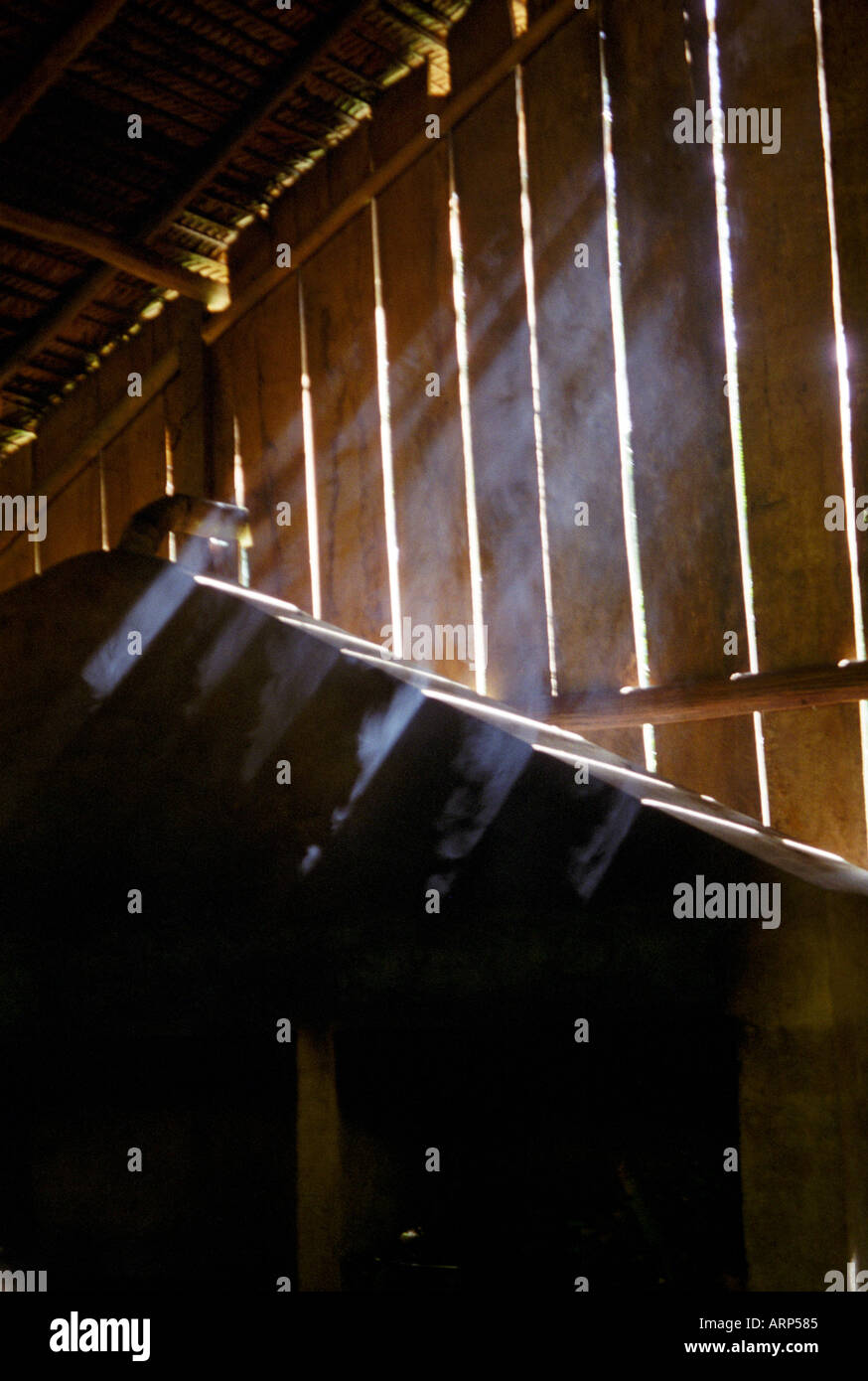 Shafts of light play on smoke as they shine through gaps in a wood slat ...