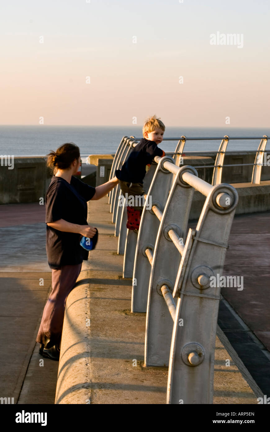 Child climbing railings childs - play Stock Photo - Alamy
