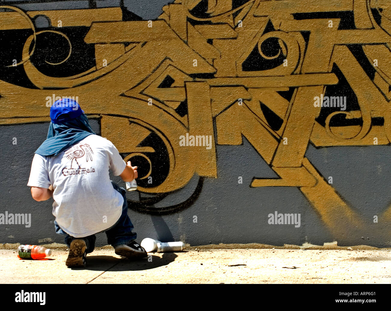 Graffiti gold wall kneeling Stock Photo - Alamy