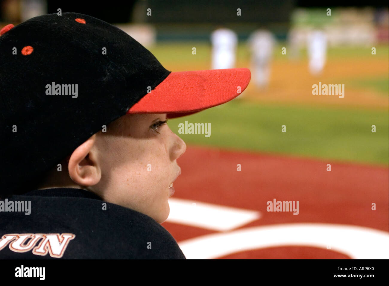 Young Boy watching baseball game over dugout Stock Photo - Alamy
