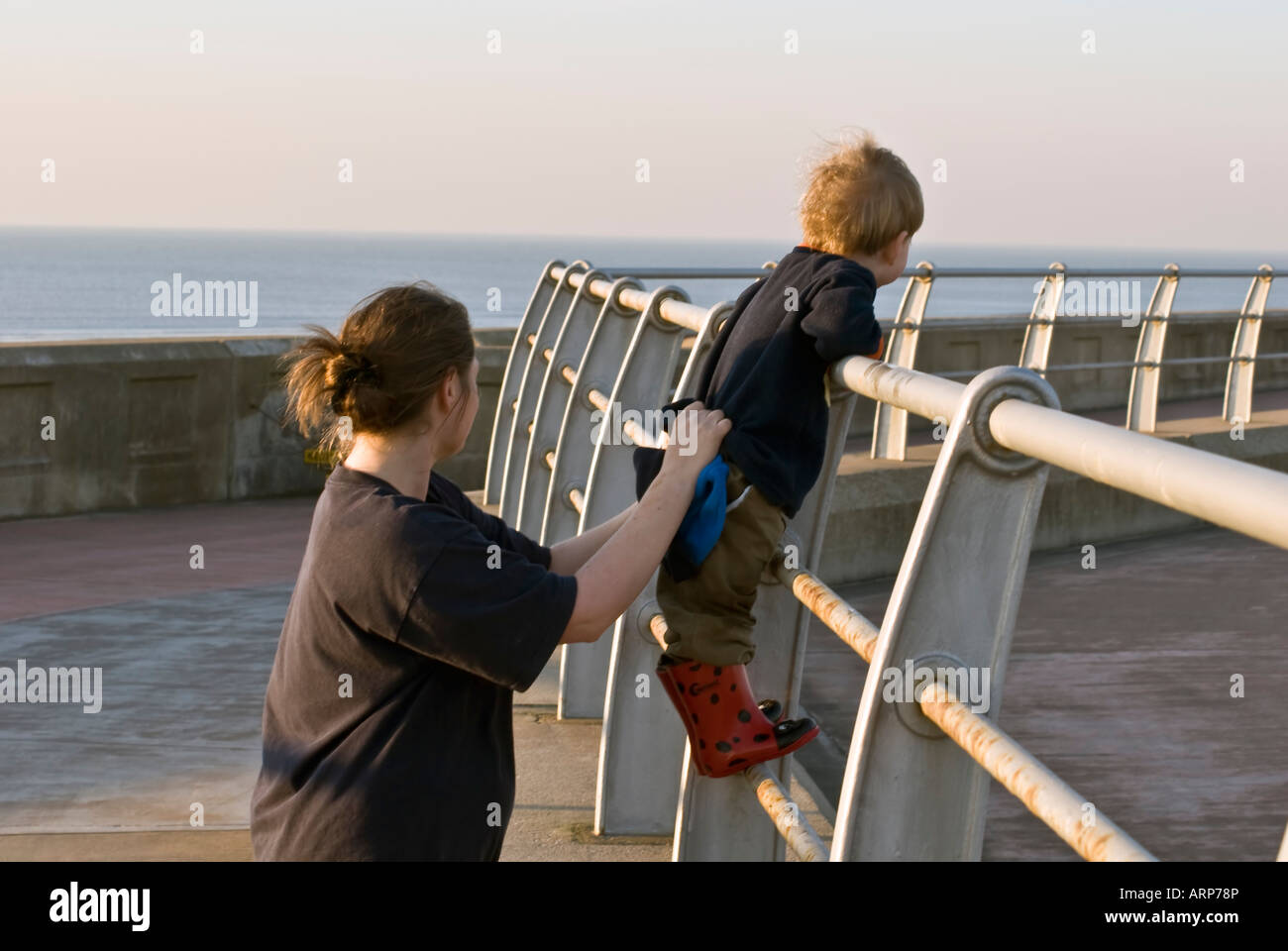 Child climbing railings childs - play Stock Photo - Alamy