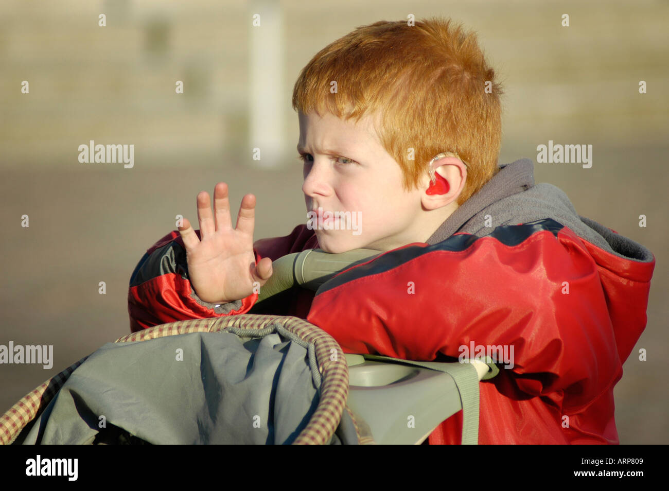 Red haired boy with hearing aid to help his ability to hear with Stock ...