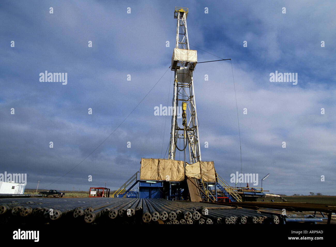 Drilling pipe sections lay on ground near oil well drill rig Snyder ...