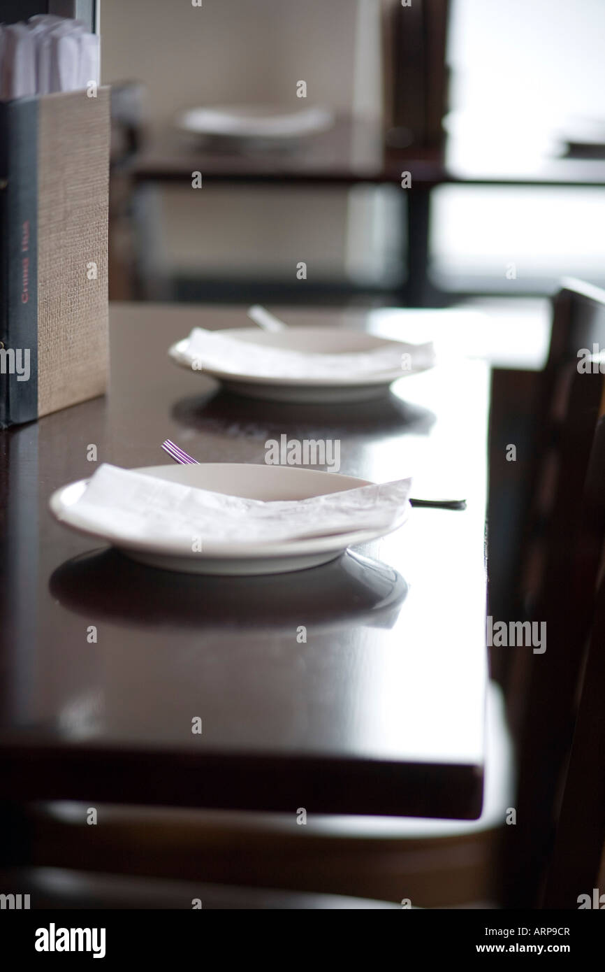 Shallow focus photo of set table with plates and silverware Stock Photo ...