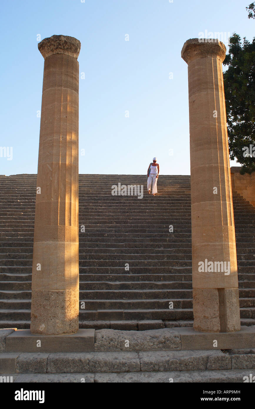 Tourist walks down step towards remains in the Acropolis lindos Rhodes ...