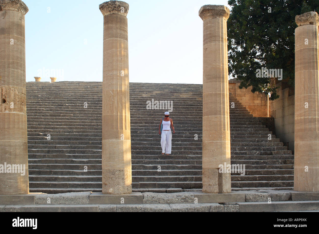 Tourist walks down step towards remains in the Acropolis Lindos Rhodes ...