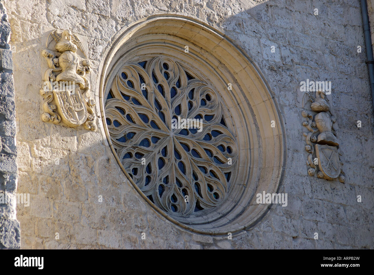 rosette in church facade franked by coat of arm sculpted in stone Stock ...
