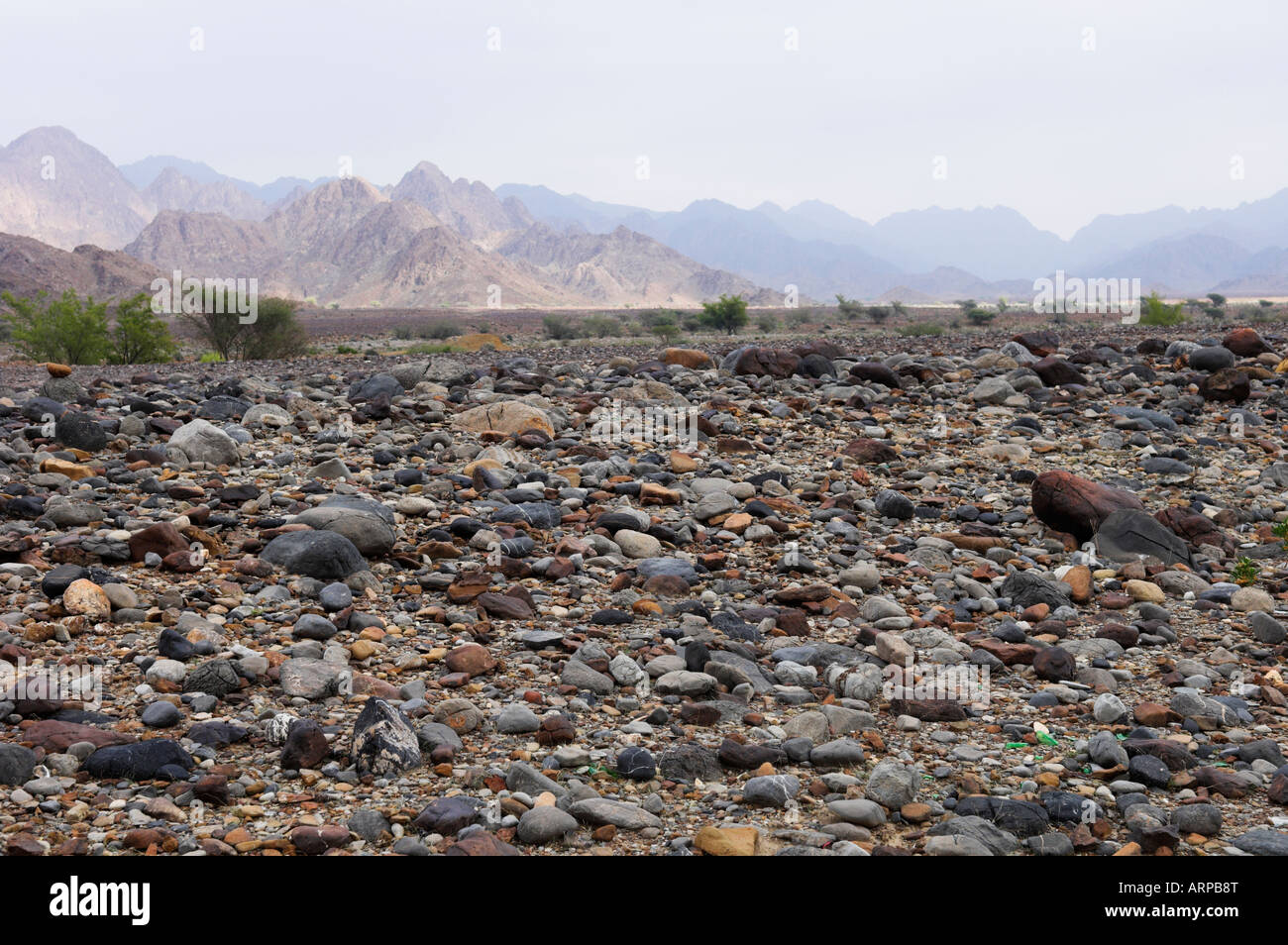 Pebbles in Wadi "Bani Awf" with typical view of Al Jabal al Akhdar ...