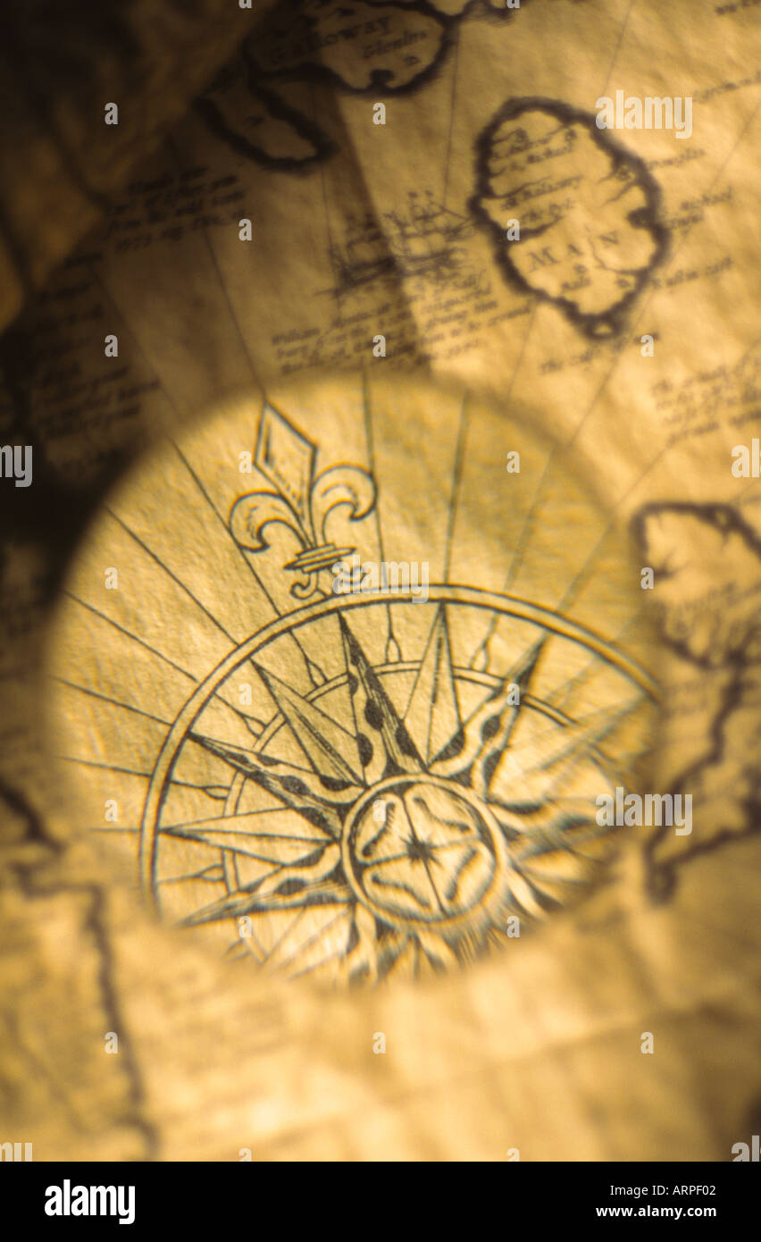 Compass sign on an old 17th century map through a magnifying glass lens ...