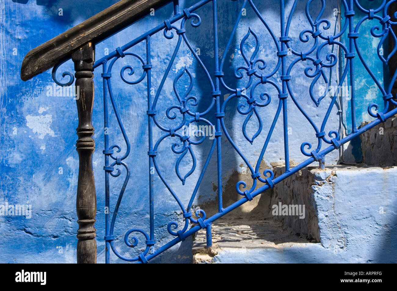 Blue railings, blue steps, blue wall, brown banisters in sunlight in ...
