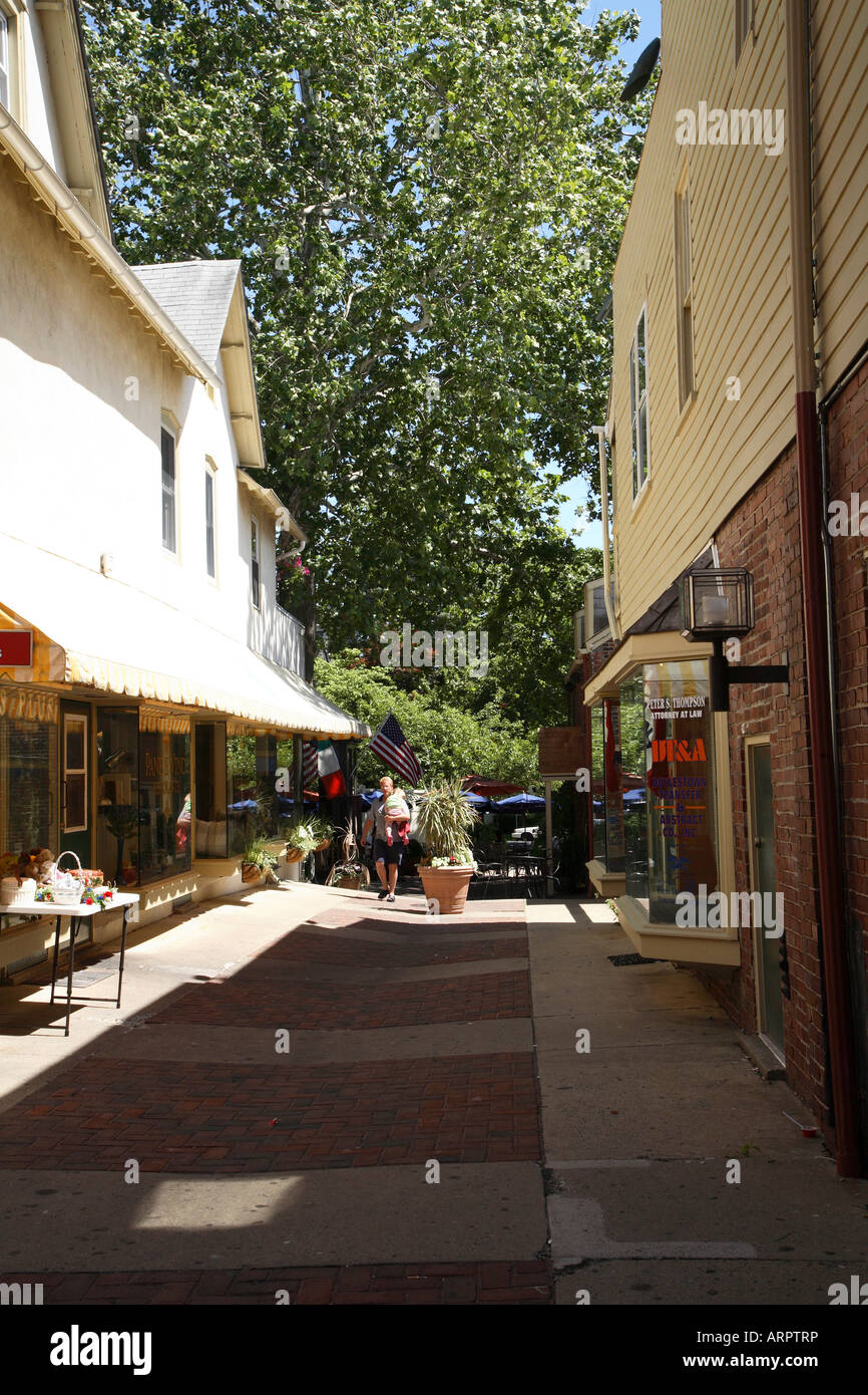 Wide brick paved walkway between two sets of shops with outdoor ...