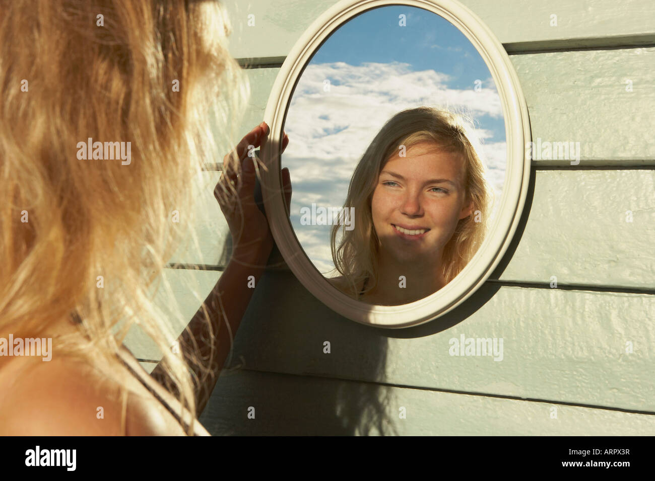 Young Woman Looking in Mirror outside Stock Photo - Alamy