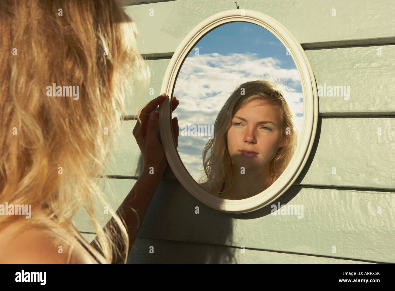 Young Woman Looking in Mirror outside Stock Photo - Alamy
