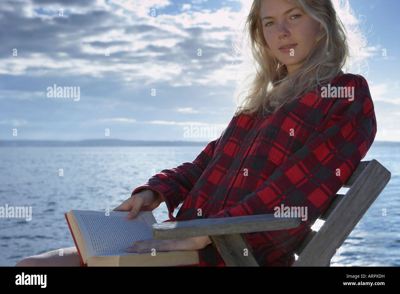 Young Woman by sea reading book Stock Photo - Alamy