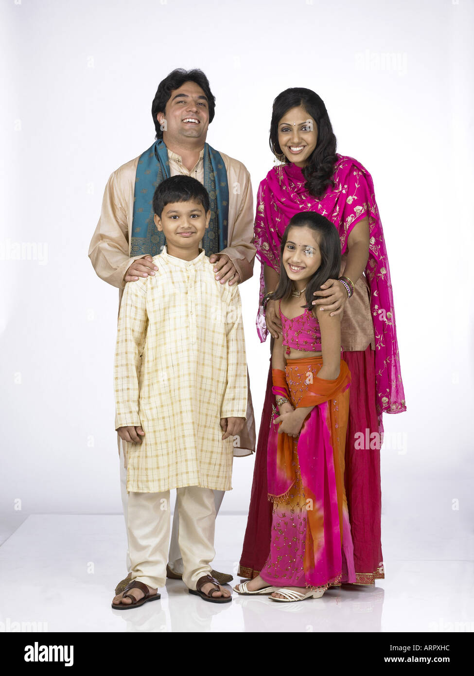 South Asian Indian family with father mother son and daughter standing ...