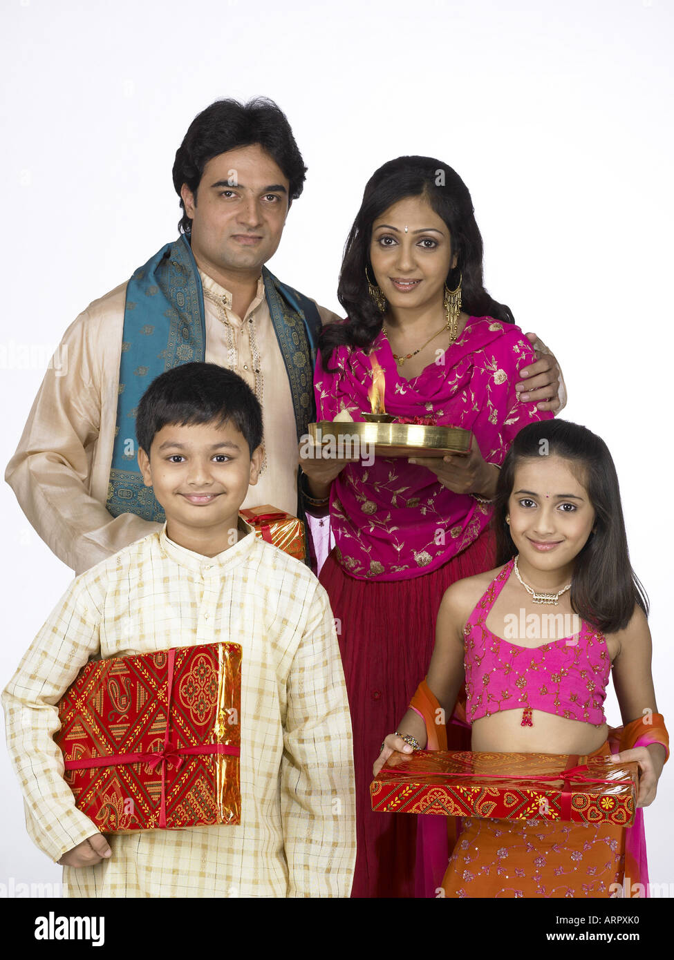 South Asian Indian family with father mother son and daughter standing ...