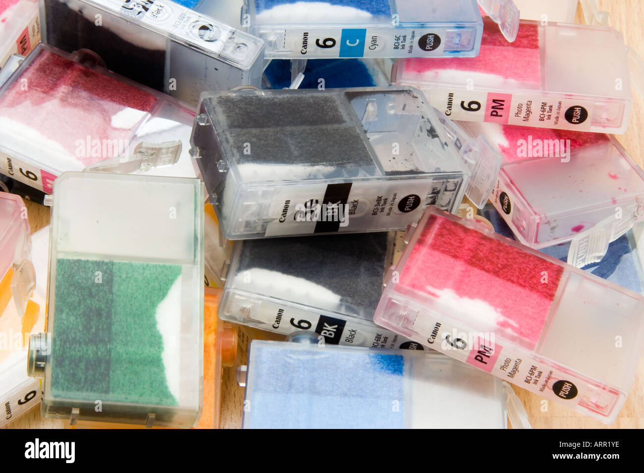 Used Canon ink cartridges. Scattered in small pile, various colours ...