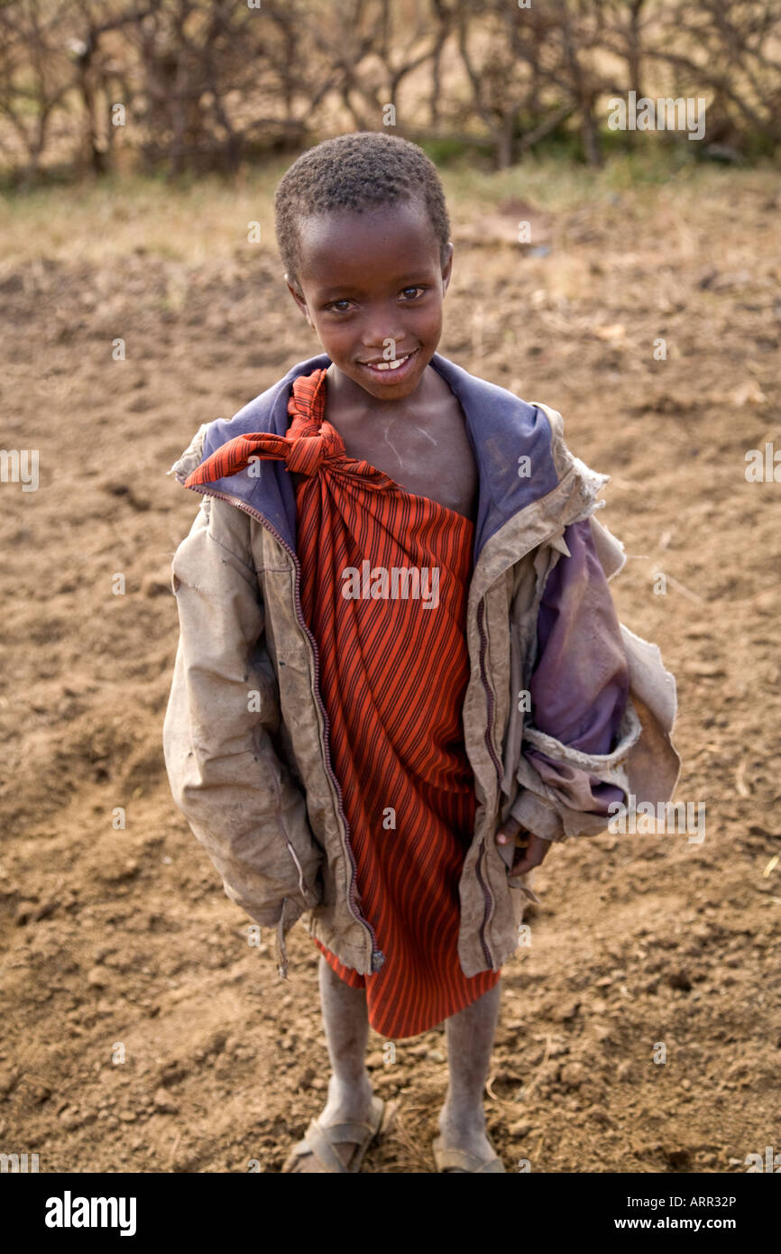 A young Maasai boy in worn clothing gives a huge smile Stock Photo - Alamy