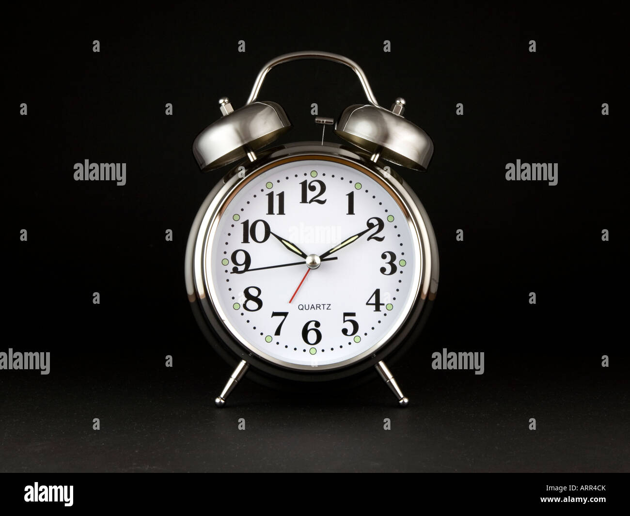 Stainless steel alarm clock on black background Stock Photo - Alamy