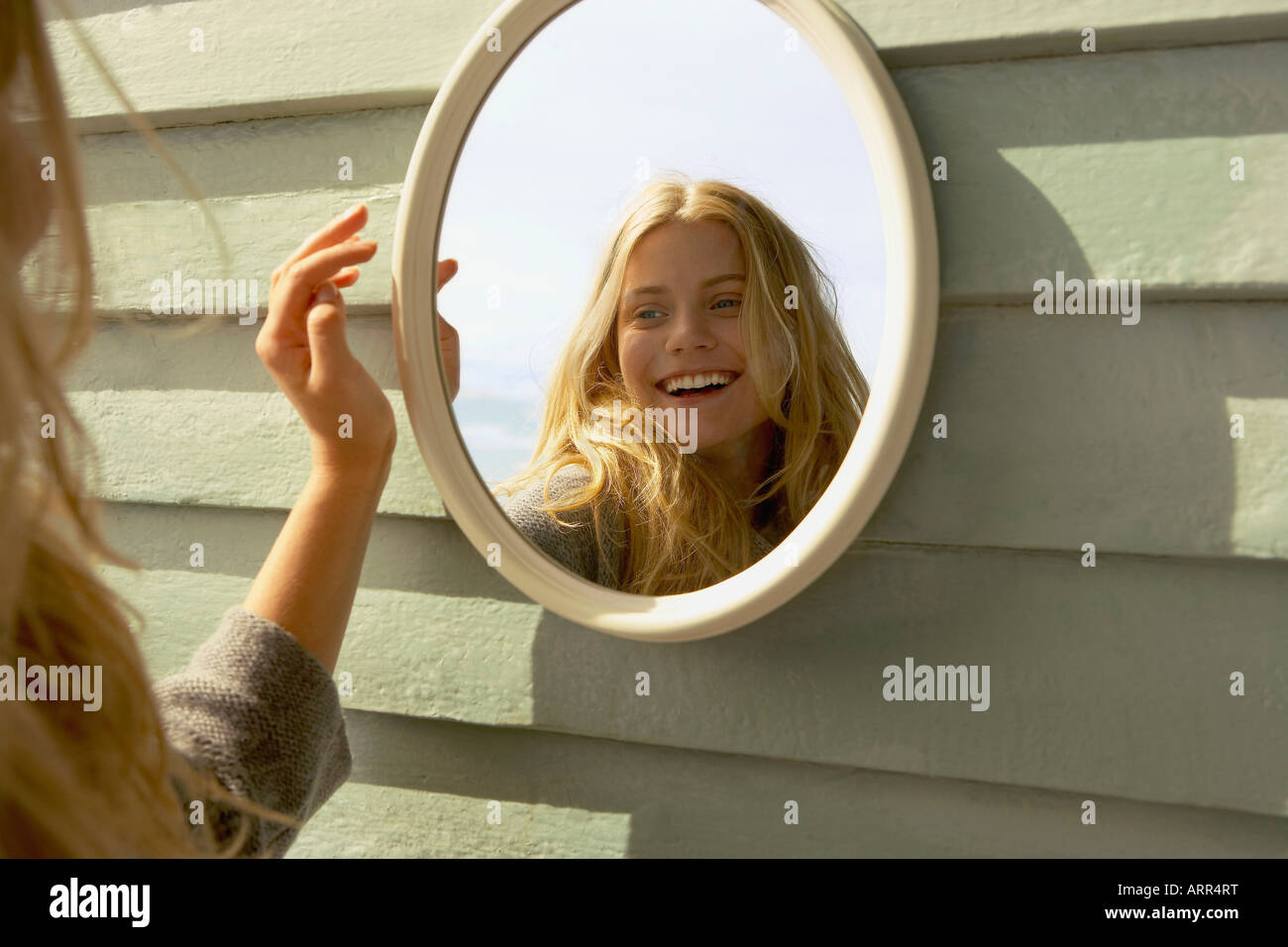 Young Woman Looking in Mirror outside Stock Photo - Alamy