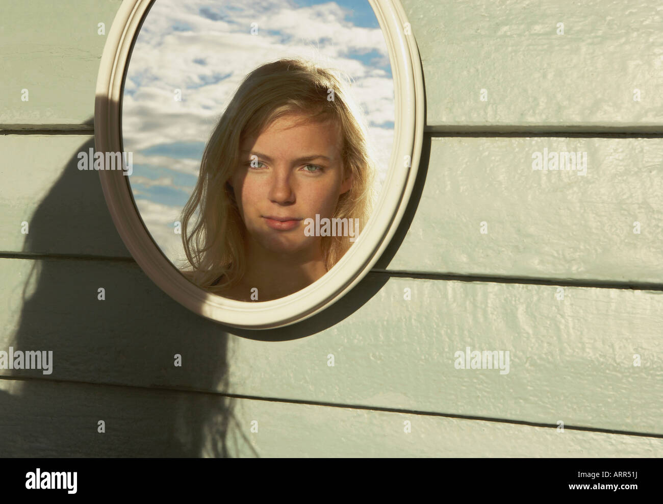 Young Woman Looking in Mirror outside Stock Photo - Alamy