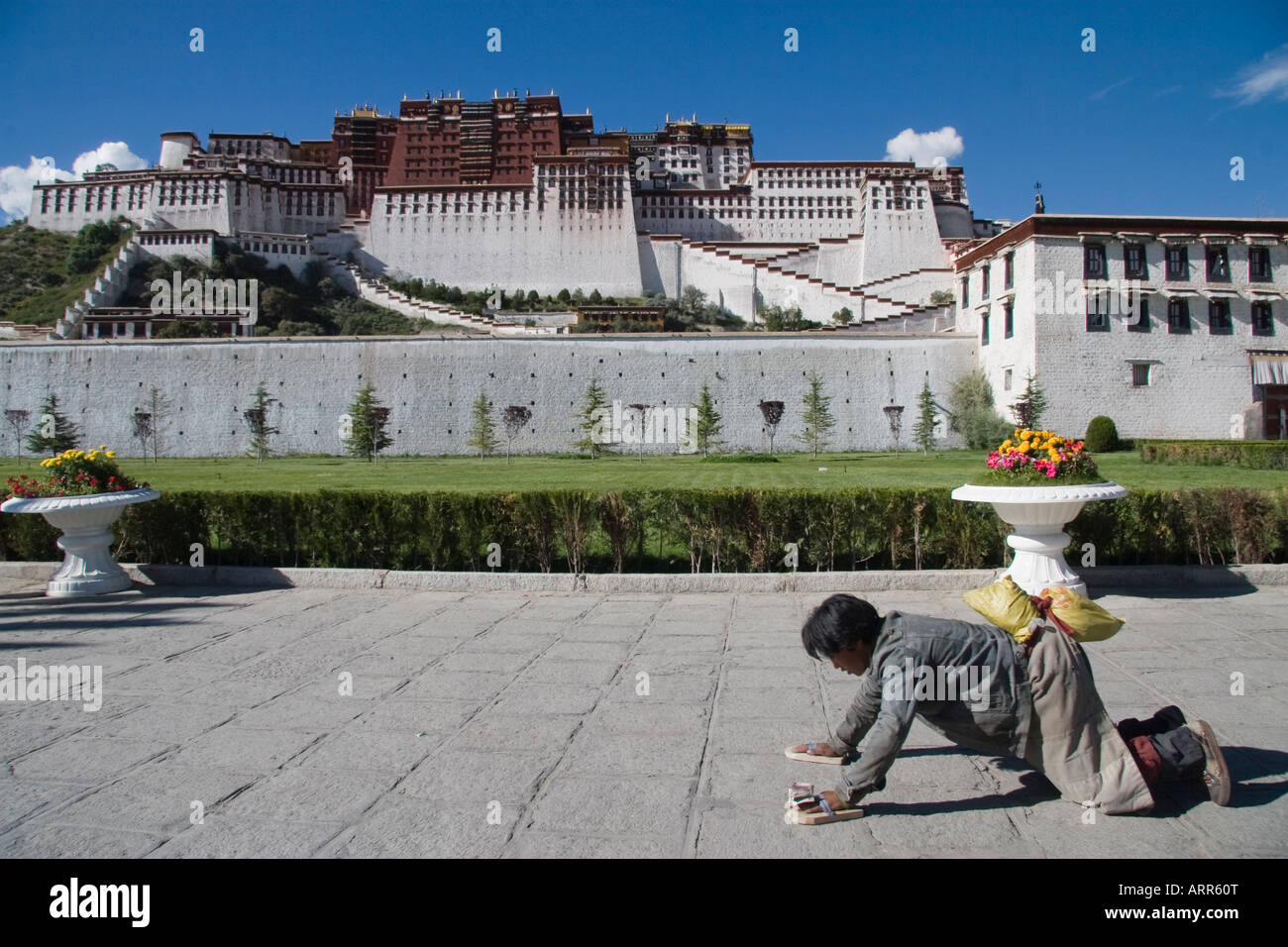 A Tibetan pilgrim before the Potala Palace in Lhasa Tibet Stock Photo ...