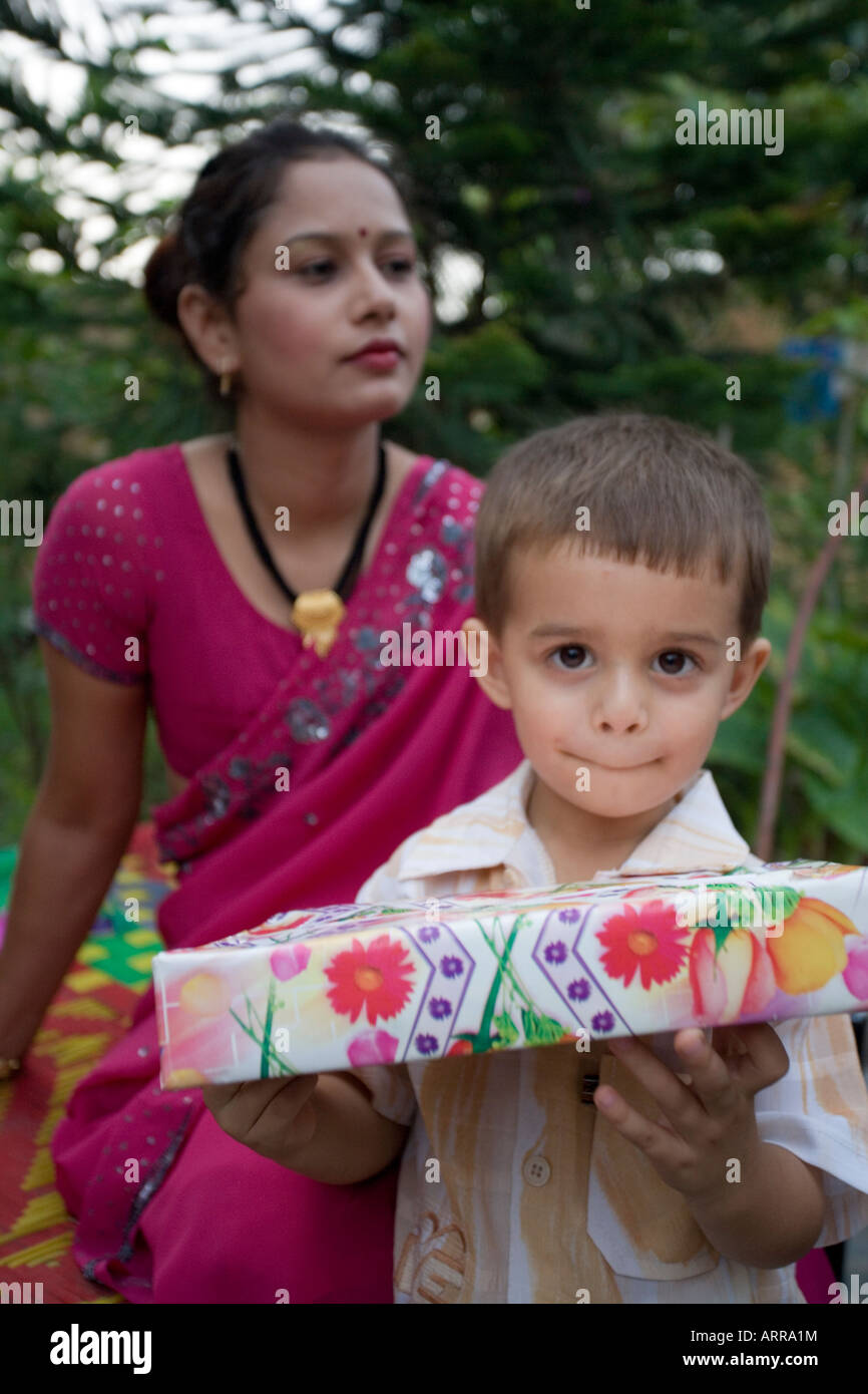 Boy holds birthday present, Pakistan, Mixed race family Stock Photo - Alamy