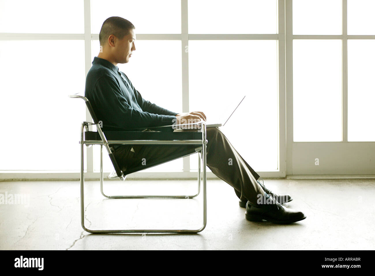Profile of Businessman Sitting in Modern Chair in Front of Windows ...