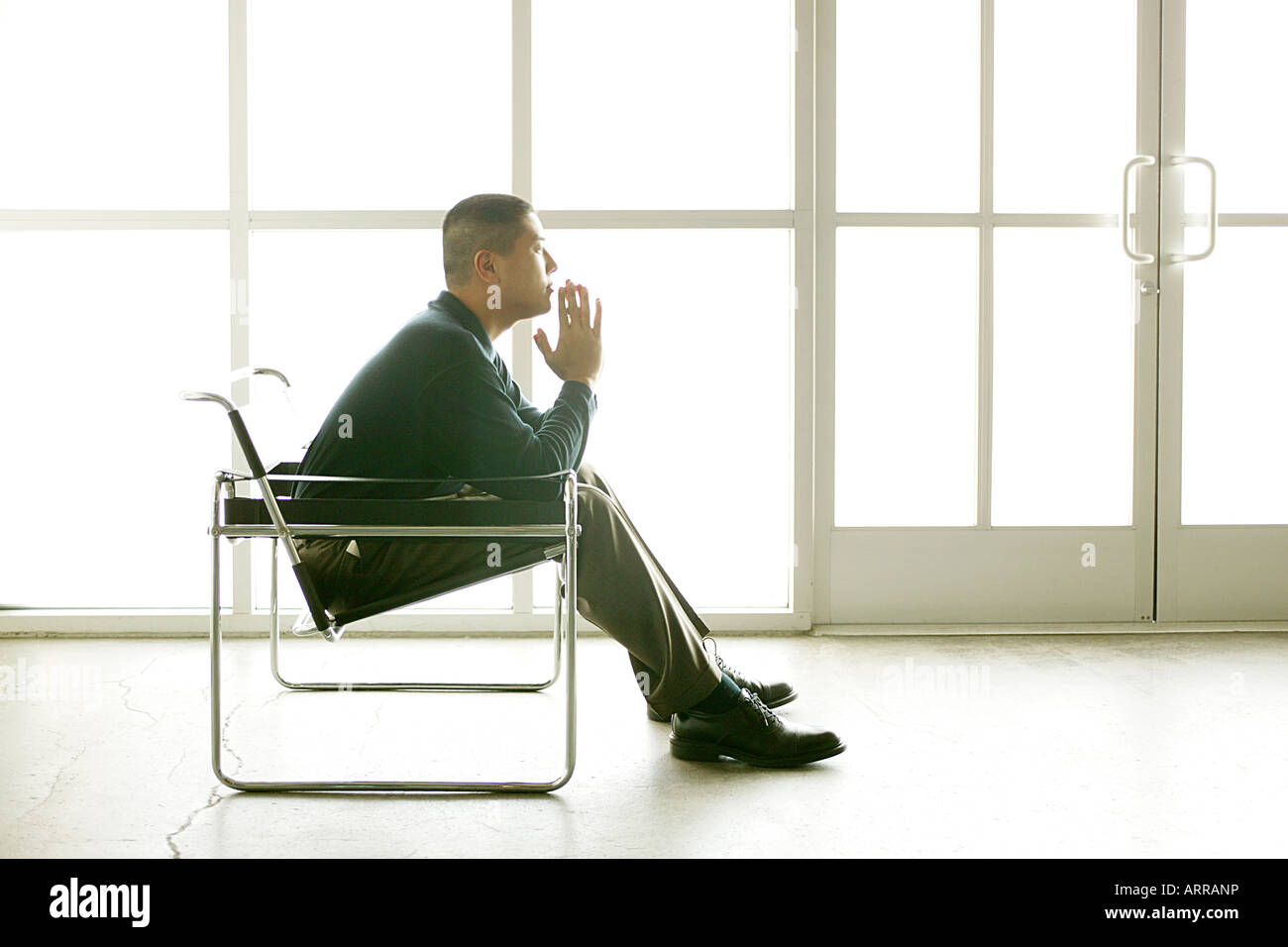 Profile of Businessman Sitting in Modern Chair in Front of Windows ...