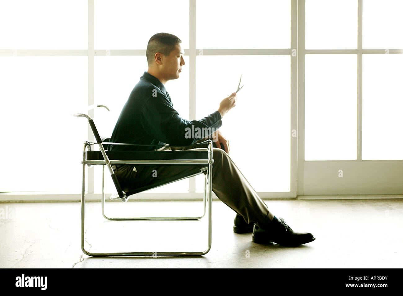 Businessman Sitting in Modern Chair Holding Cell Phone in Front of ...