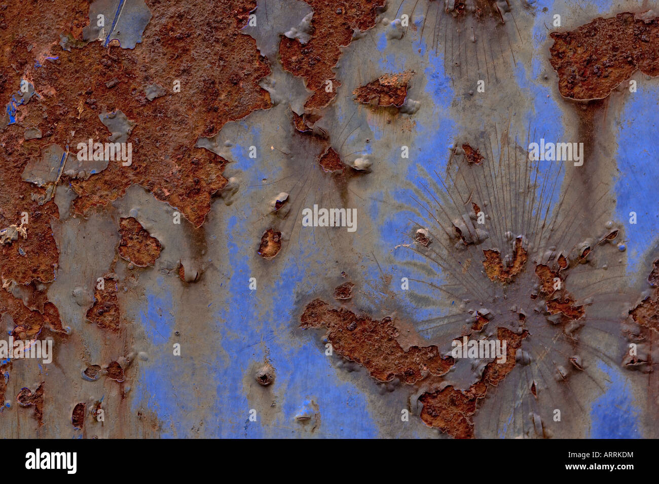 Blue paint chipping and flaking of from a battered and weathered metal ...