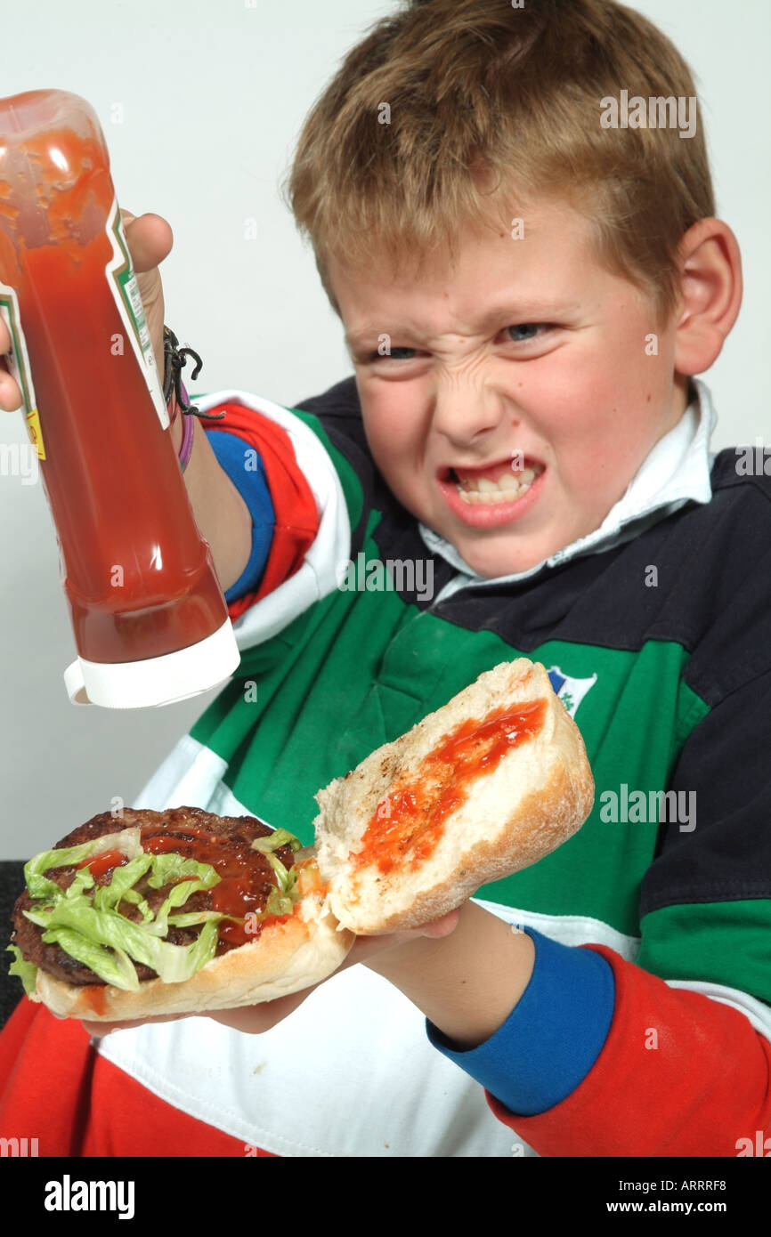 Boy with beefburger and tomato sauce squeezy bottle Stock Photo - Alamy