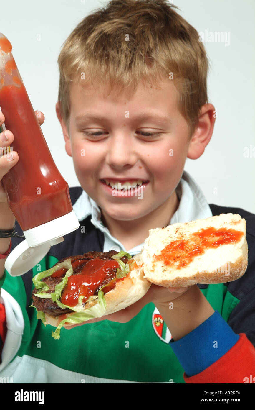 Boy with beef burger and tomato sauce squeezy bottle Stock Photo - Alamy