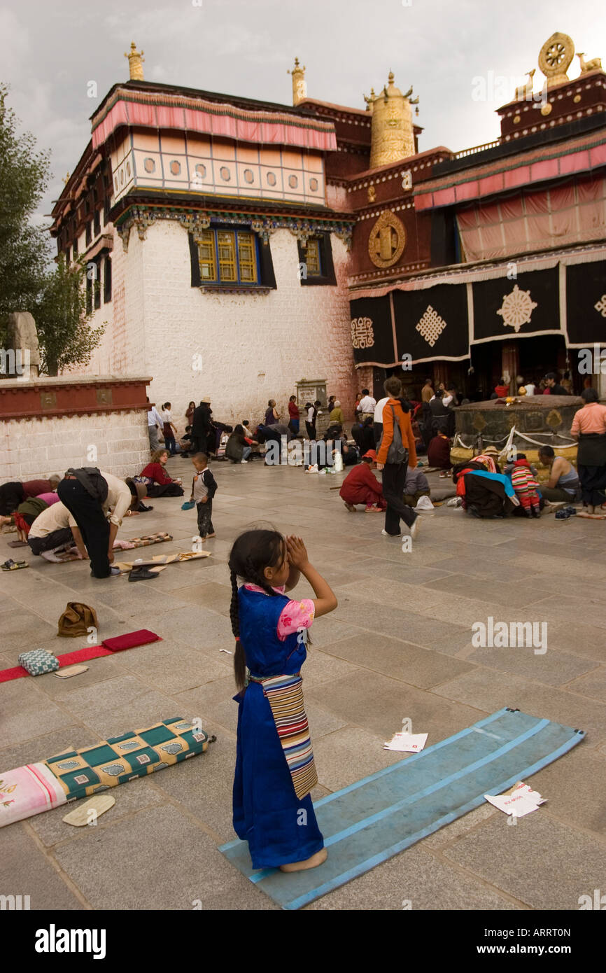 Tibetan girl prostrating in front of the Jokhang Temple, Lhasa Stock ...
