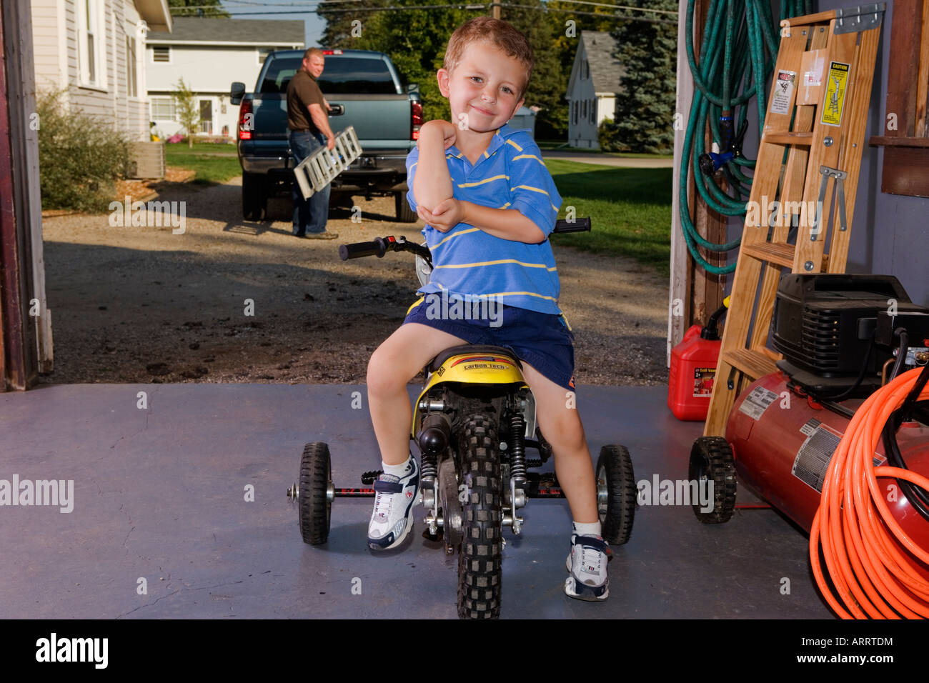 Boy on motorcycle in garage Stock Photo - Alamy