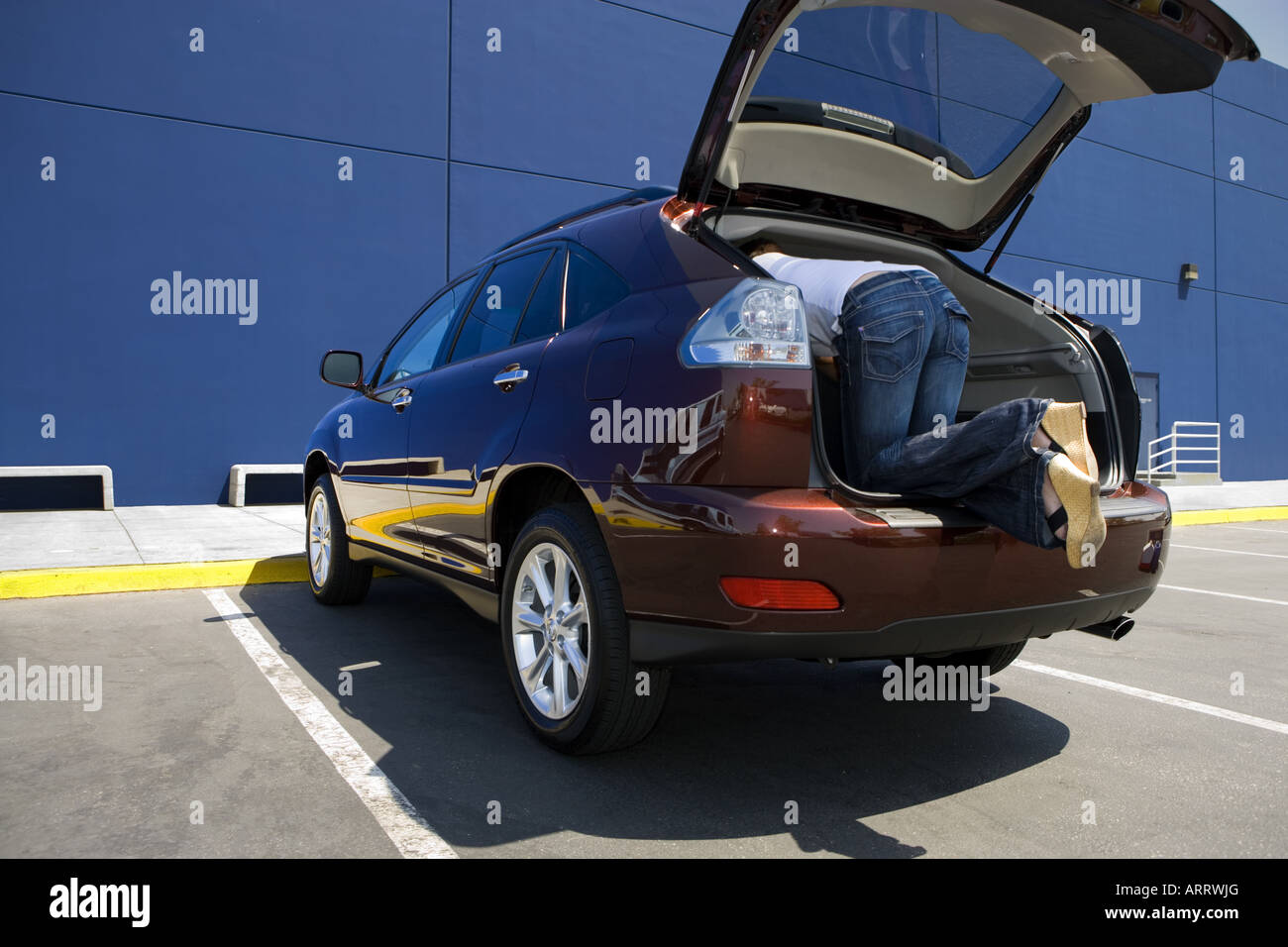 Woman packing items into trunk Stock Photo - Alamy