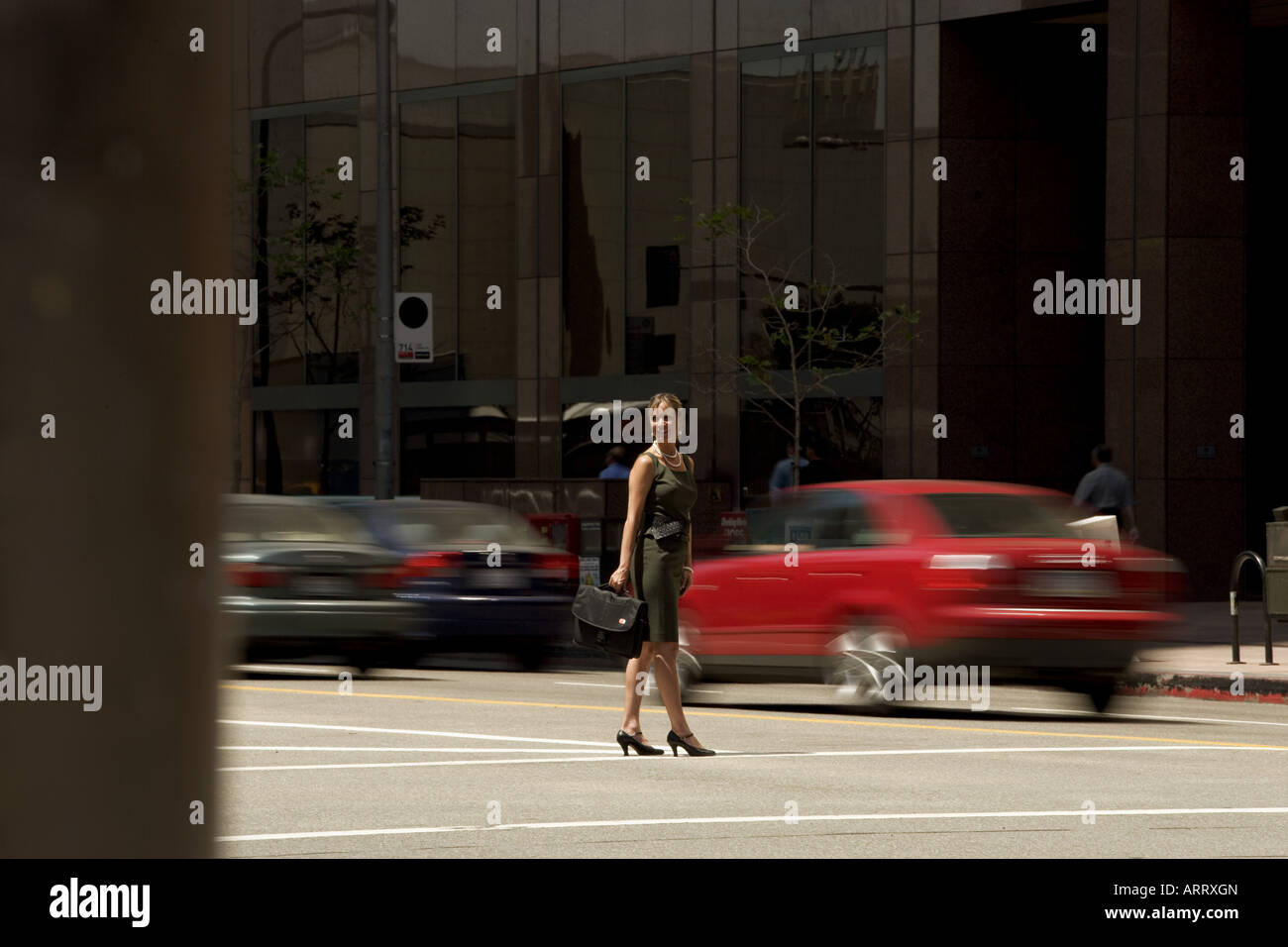 Woman walking through crosswalk in intersection Stock Photo - Alamy